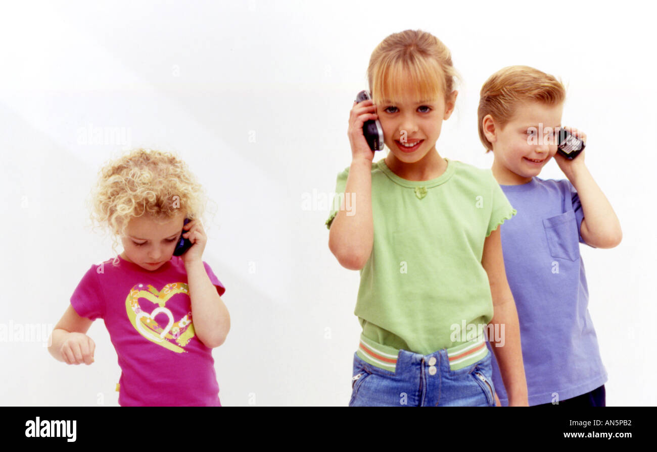 Three young children play with cell phones Stock Photo - Alamy