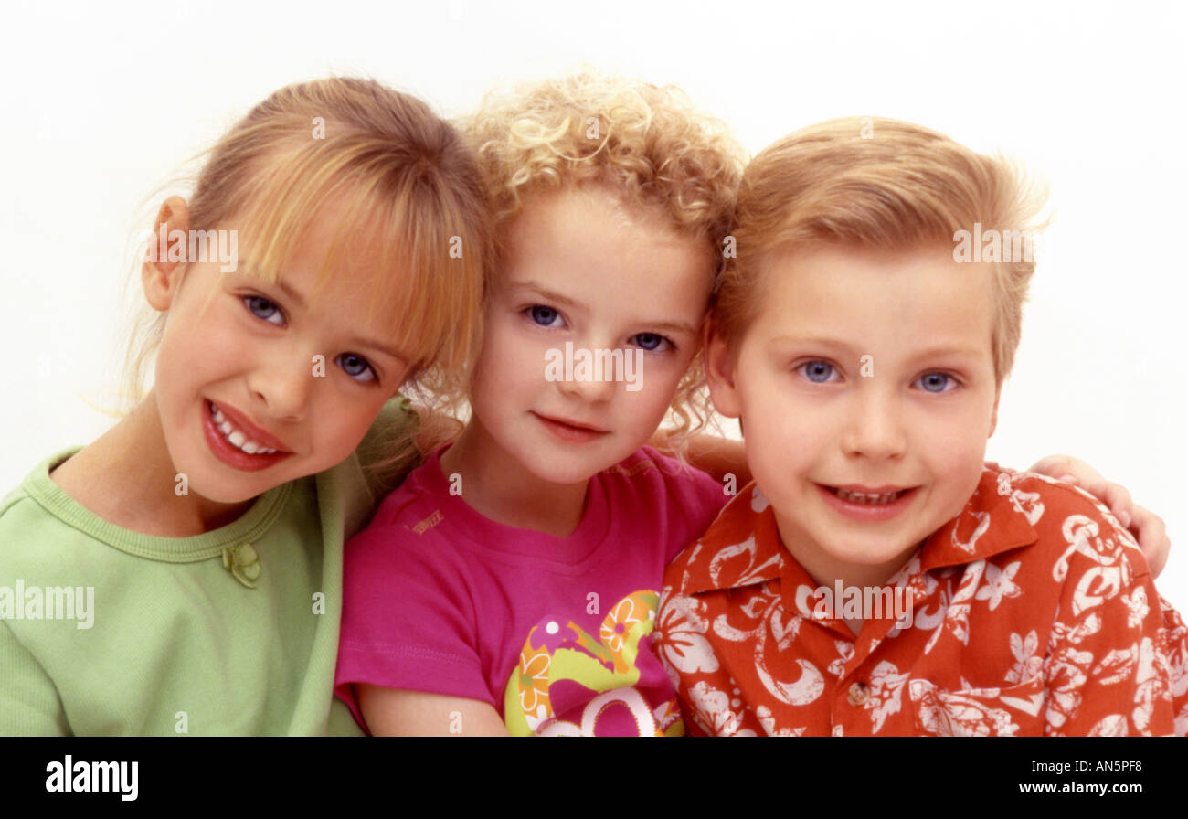 Three young children sitting happily Stock Photo - Alamy