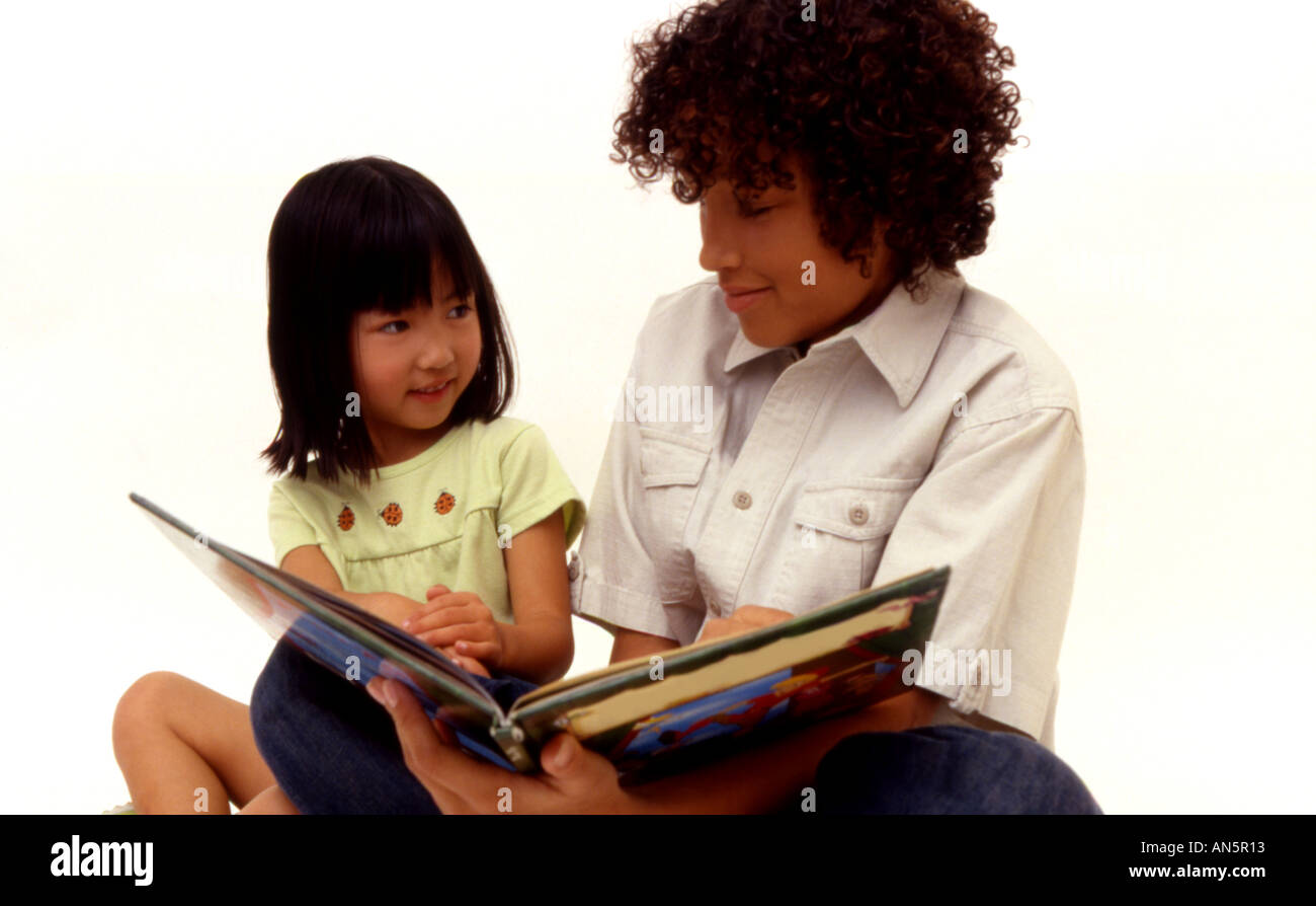 Young boy reading a story to young girl Stock Photo - Alamy