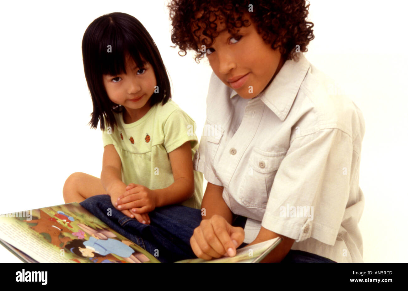 A young boy and girl read a book together Stock Photo - Alamy