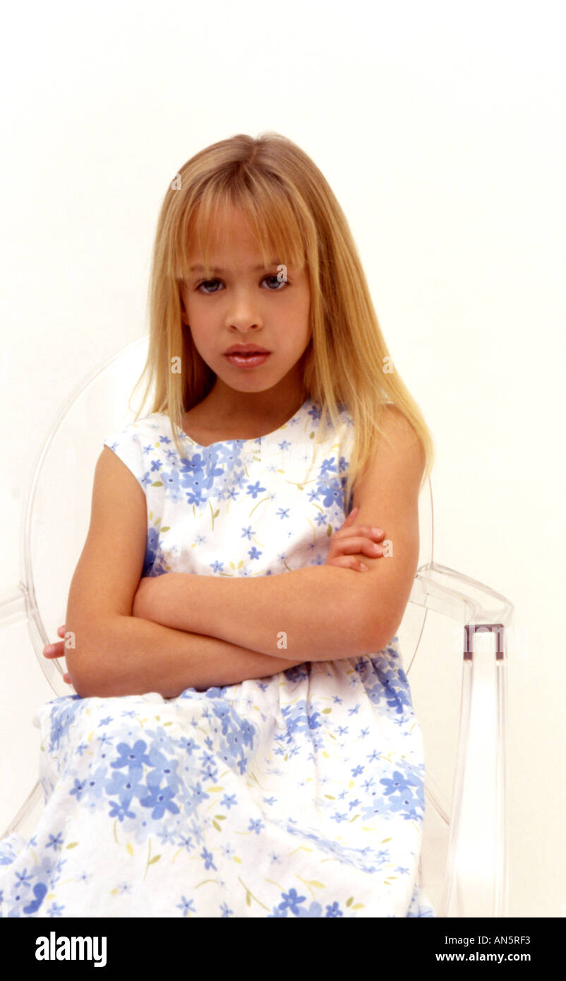 Young girl in floral dress sitting in chair annoyed Stock Photo - Alamy