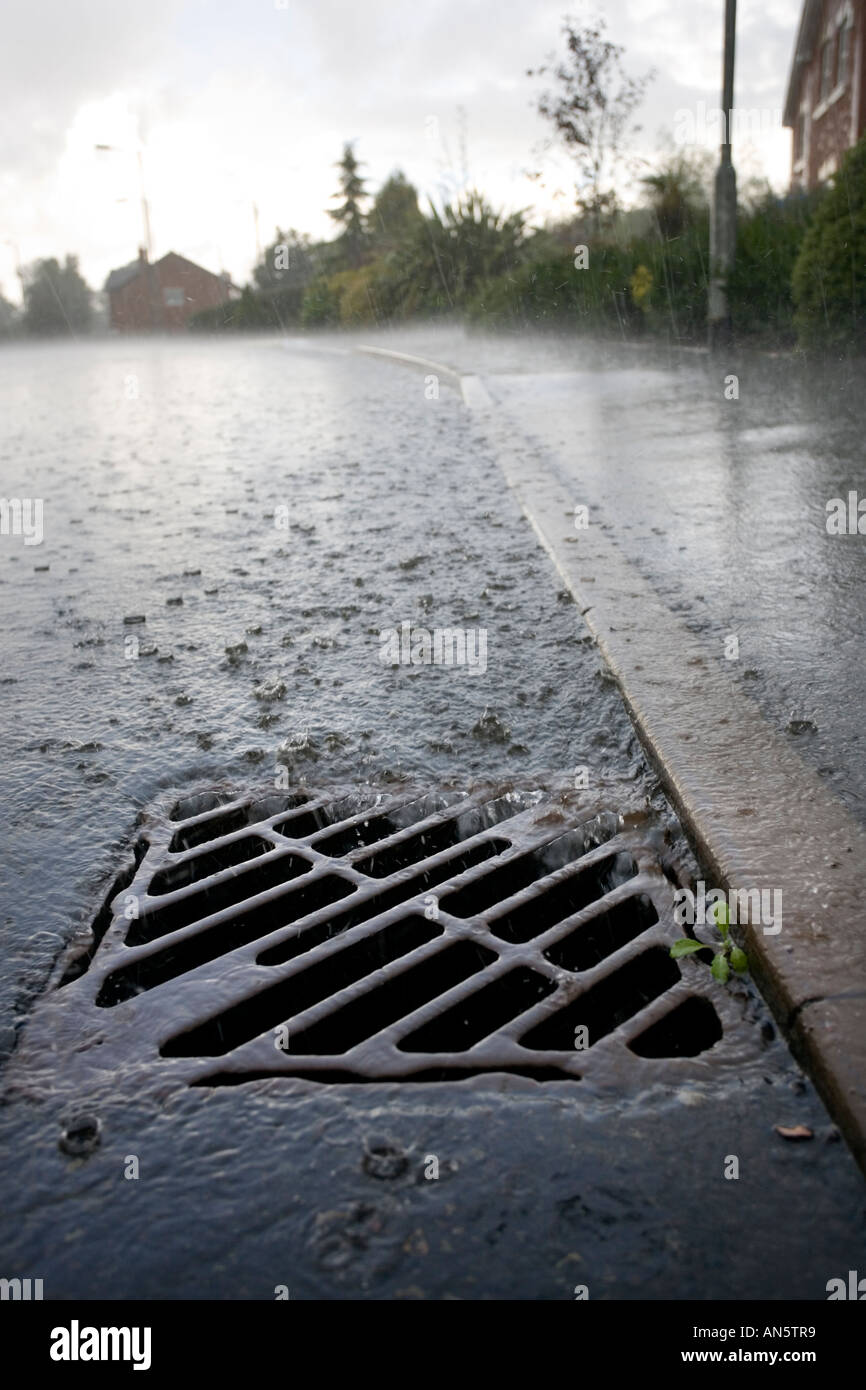 Rainwater flowing down a drain at the side of a road in Redditch ...