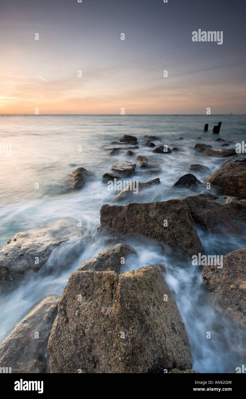 Water lapping over rocks in pre-dawn light on Hayling Island, Hampshire ...