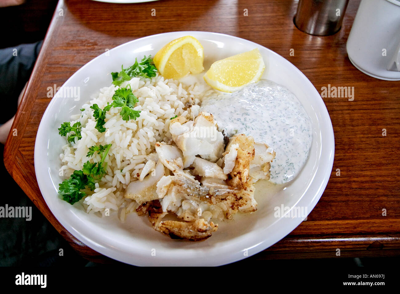 Lunch of fresh caught cod fried in butter aboard fishing boat in fjord ...