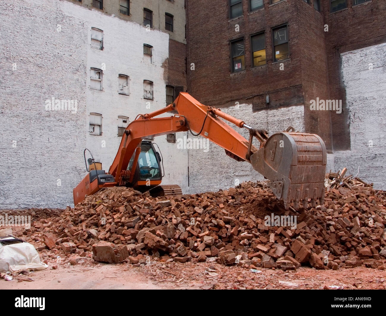 Backhoe moving bricks from demolished building on Manhattan real estate ...