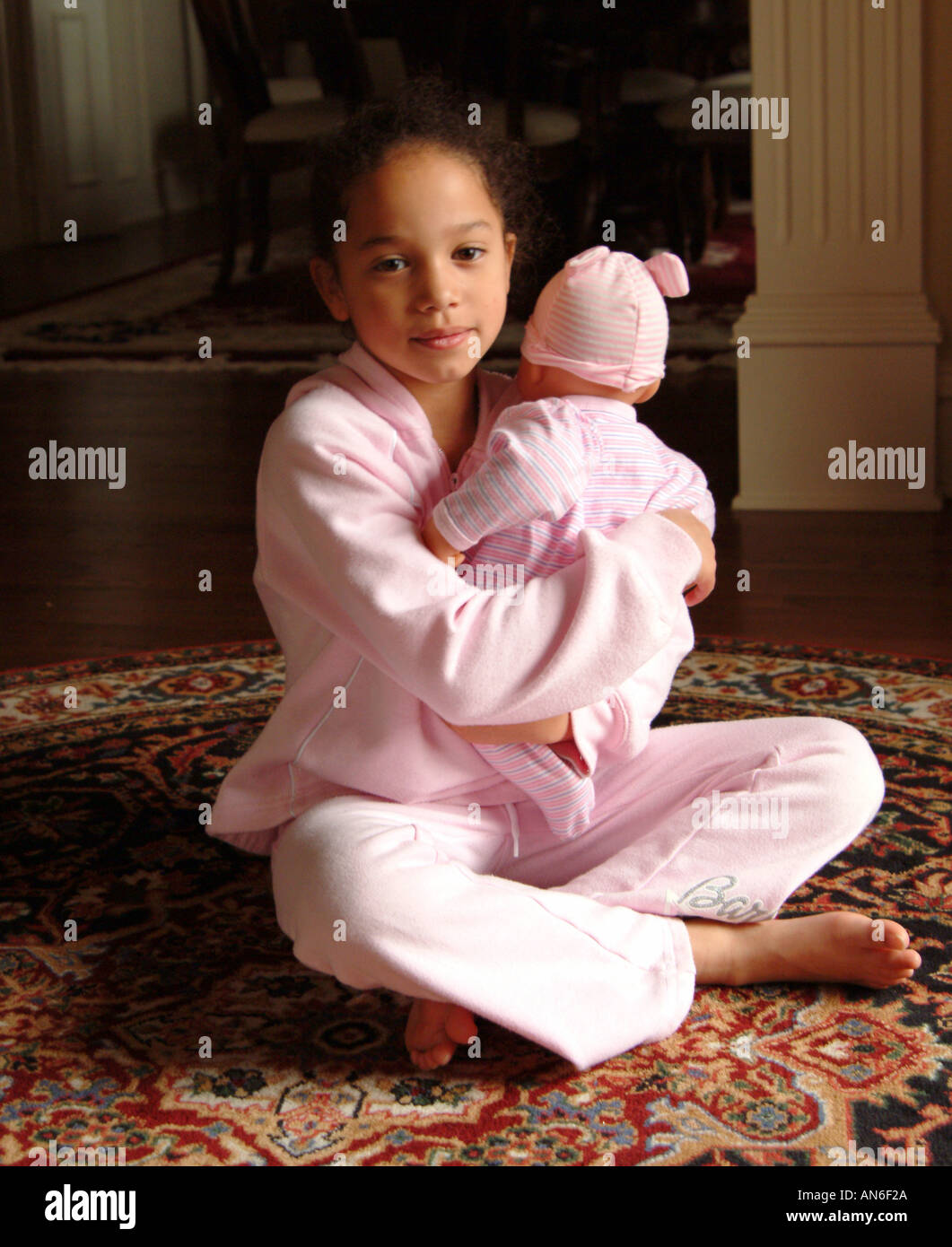 Little girl holding a doll Stock Photo - Alamy