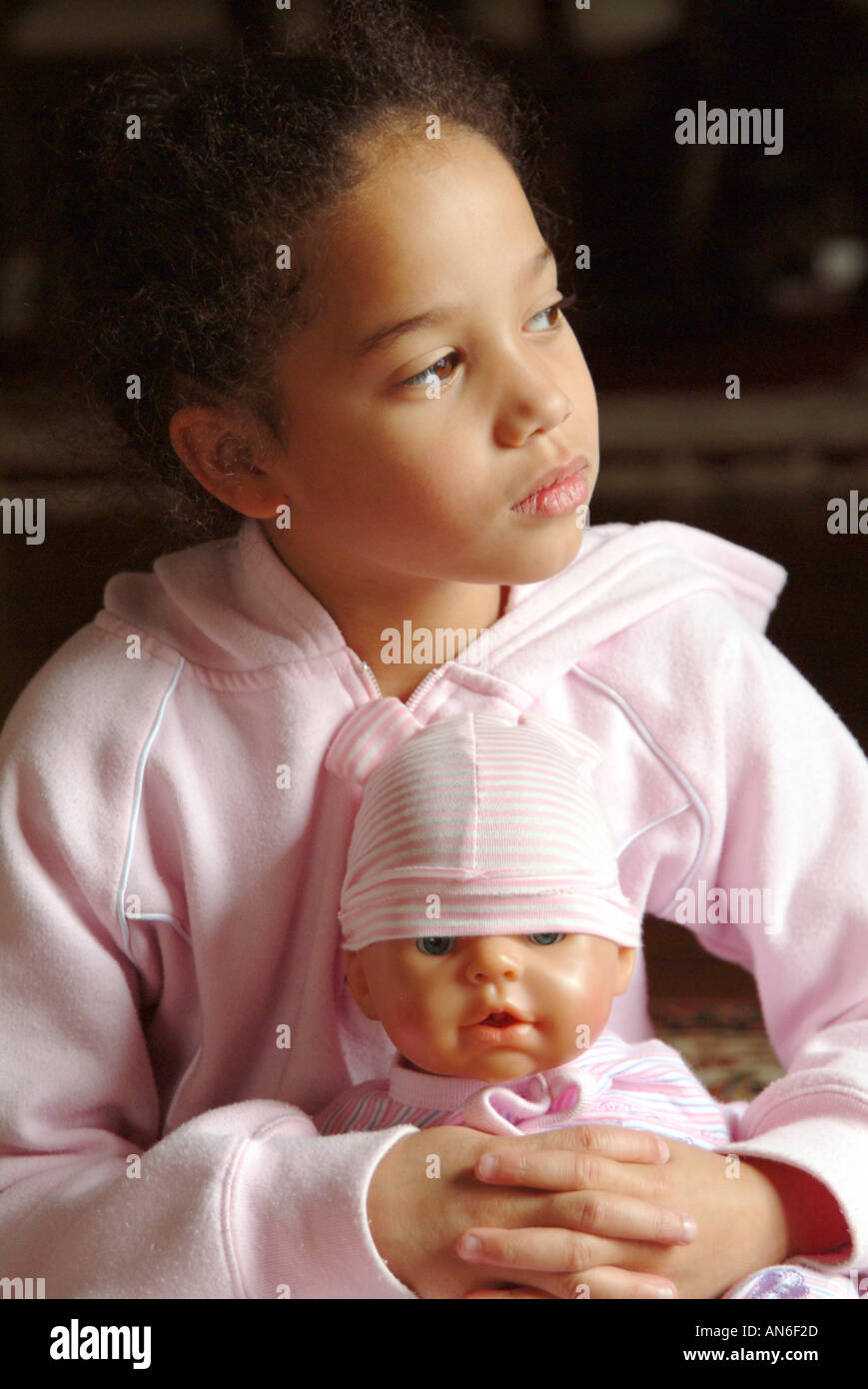Little girl holding a doll Stock Photo - Alamy