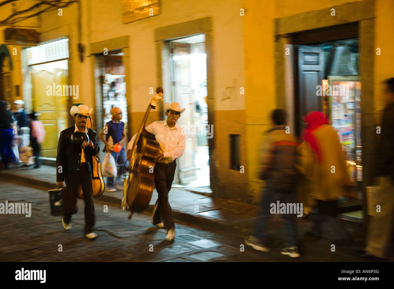 MEXICO Guanajuato Mariachi band members walking down street at night ...