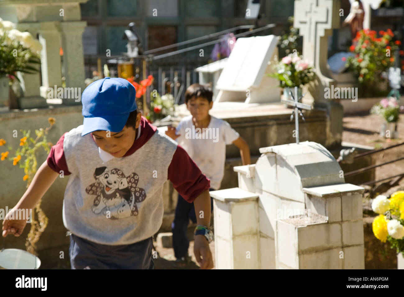 MEXICO Guanajuato Young boys running in cemetery carrying buckets of ...