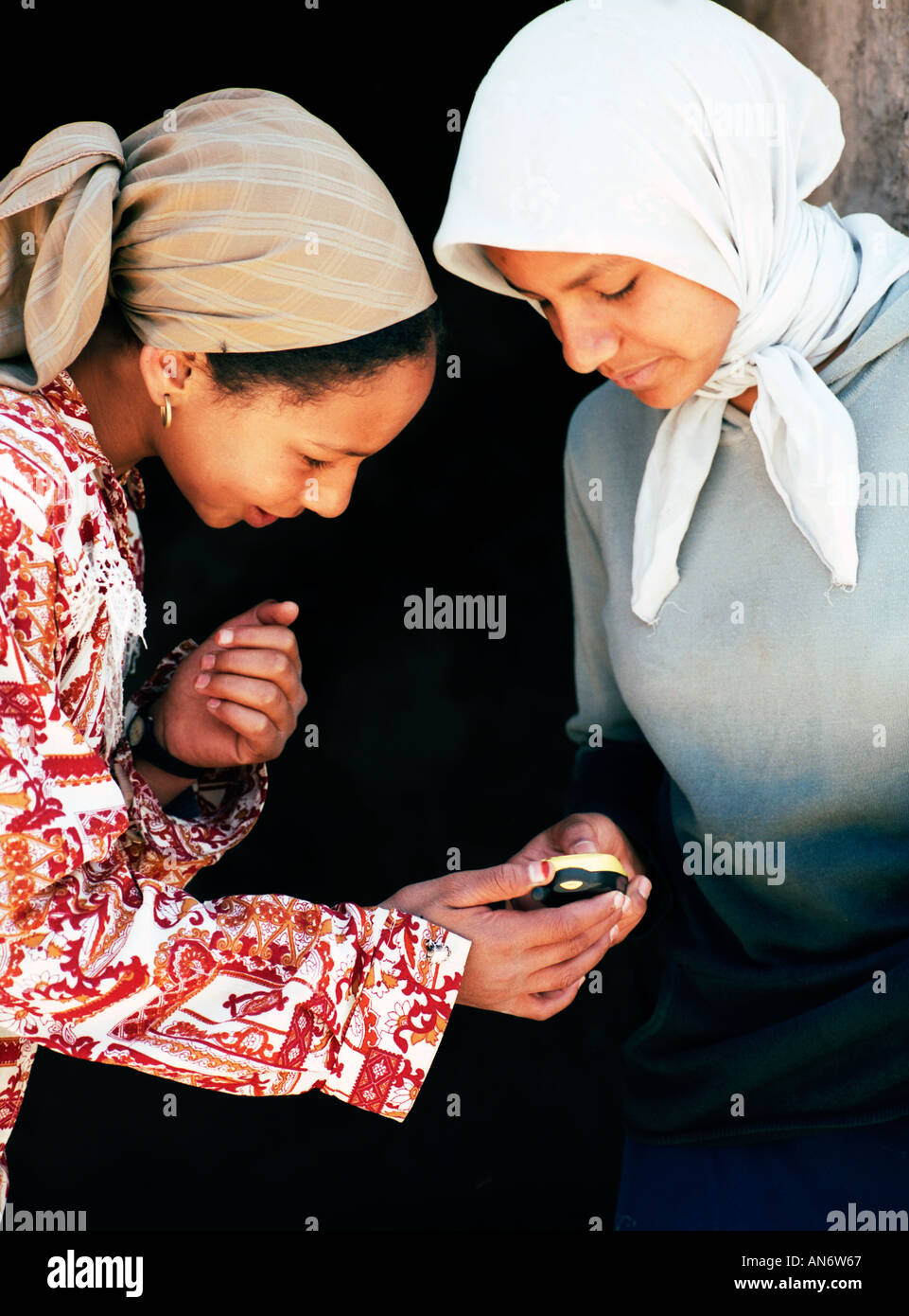 Two muslim girls using mobile phone Stock Photo - Alamy