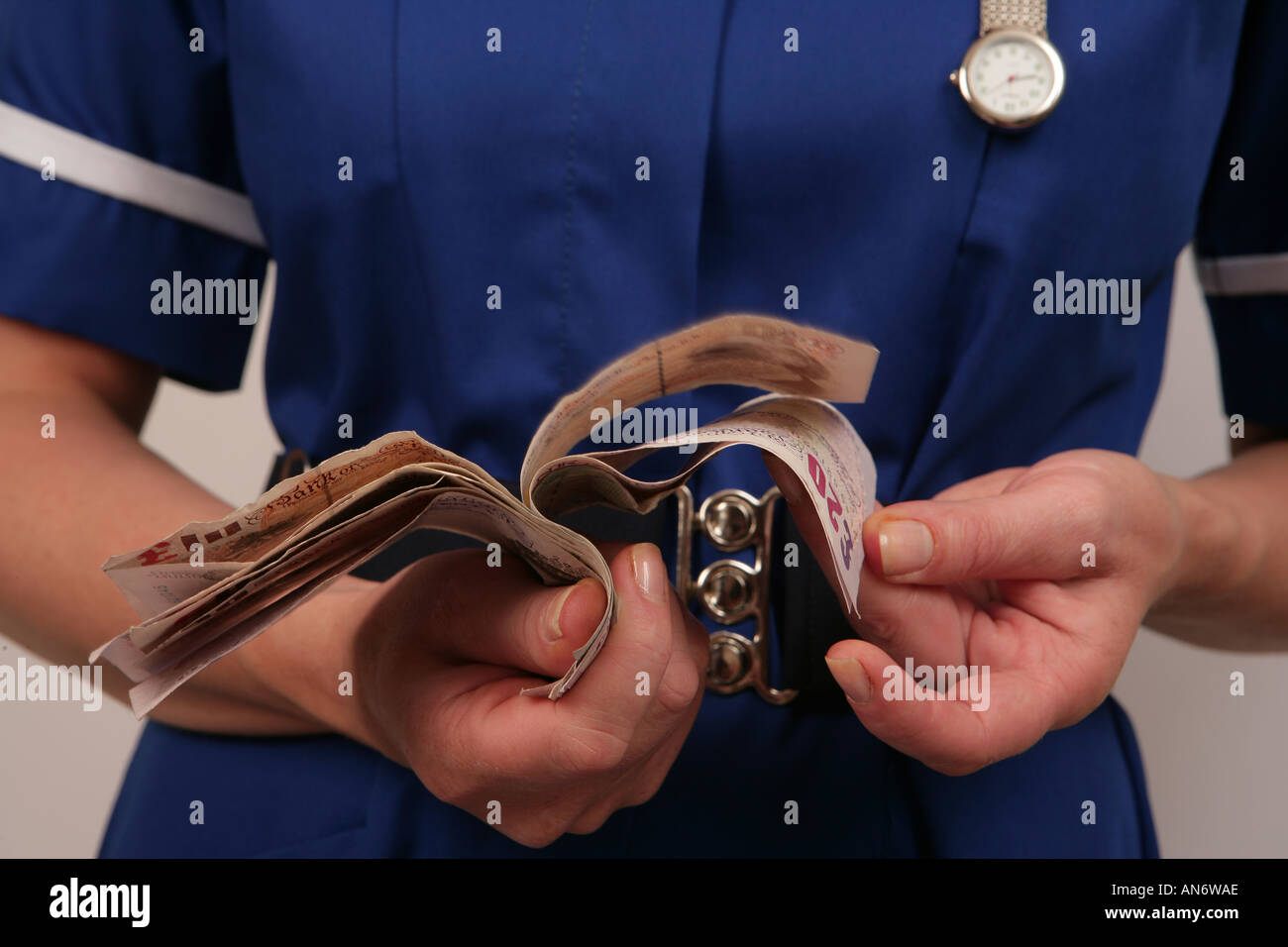 Nurse wearing blue uniform counting her money wages Stock Photo - Alamy