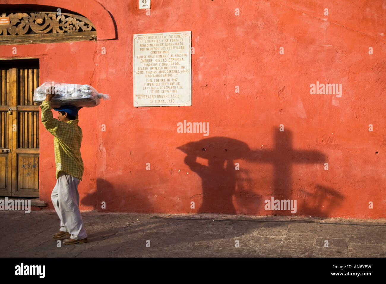 MEXICO Guanajuato Man carrying a load on his head walk past church ...