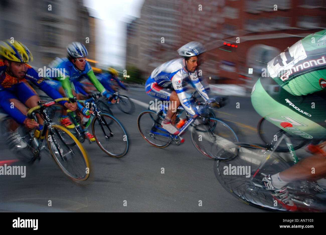 Bike racers race through a city street at dusk Stock Photo - Alamy