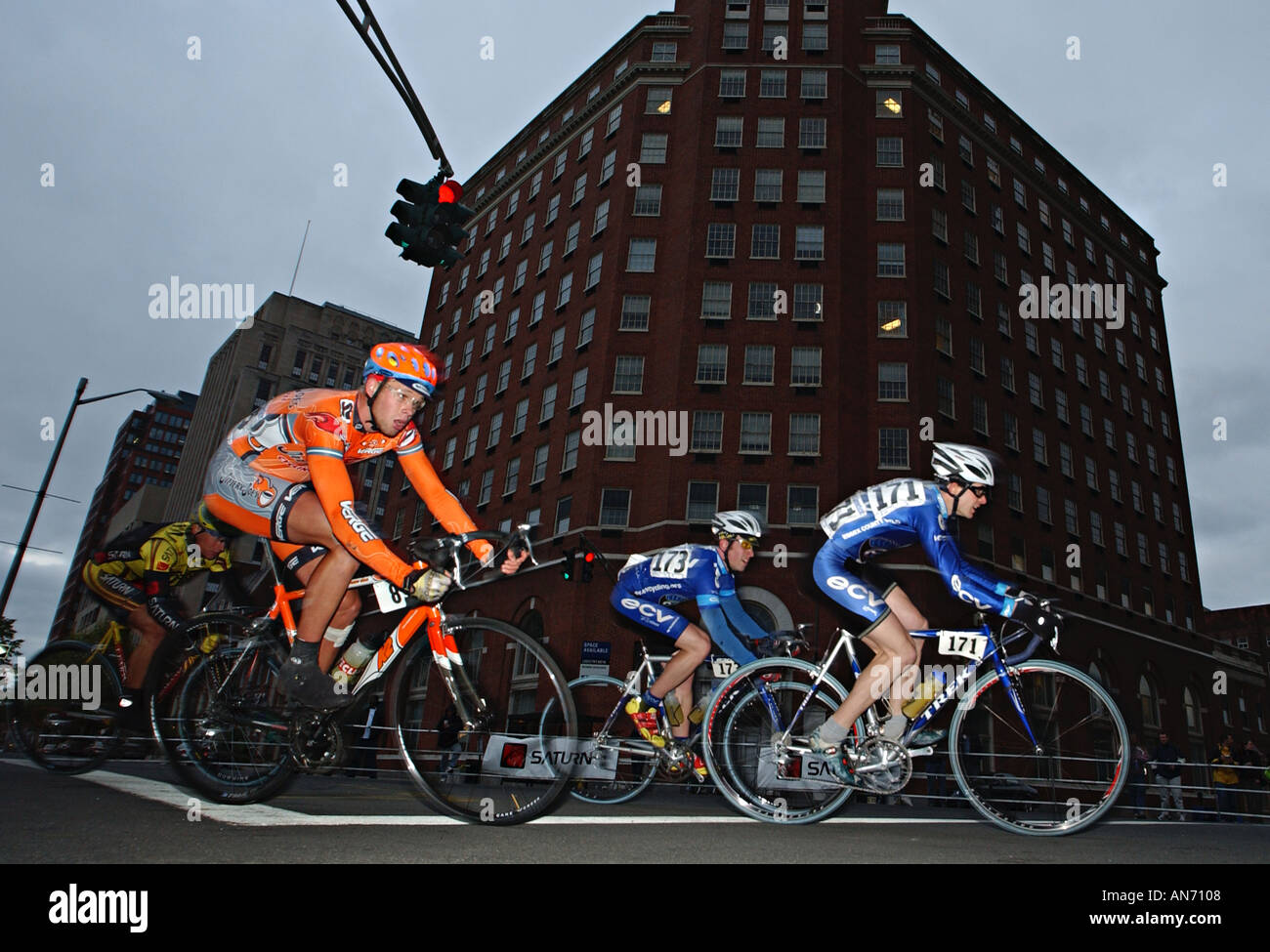 Bike racers race through a city street at dusk Stock Photo - Alamy