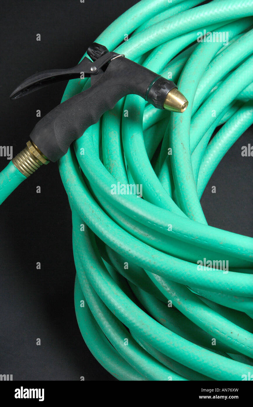 A garden hose coiled with a sprayer Stock Photo - Alamy