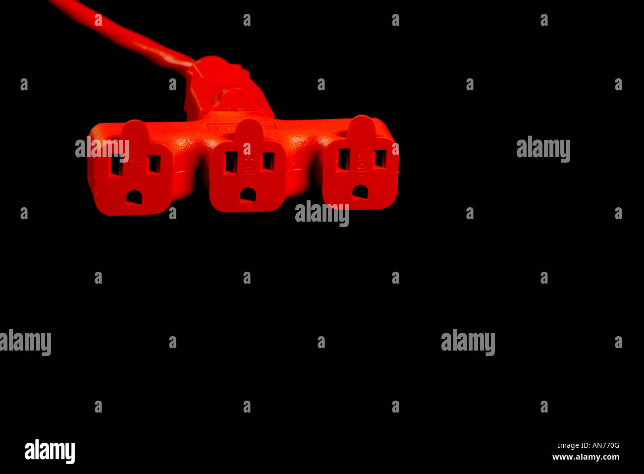 An orange extension cord connected to a three way splitter Stock Photo ...
