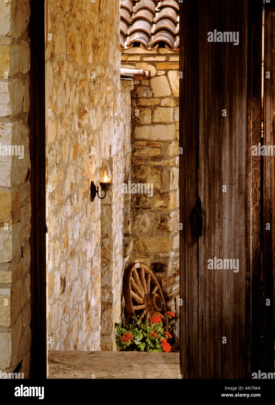 WOODEN DOOR and WAGON WHEEL at a SPANISH STYLE HACIENDA built of stone ...