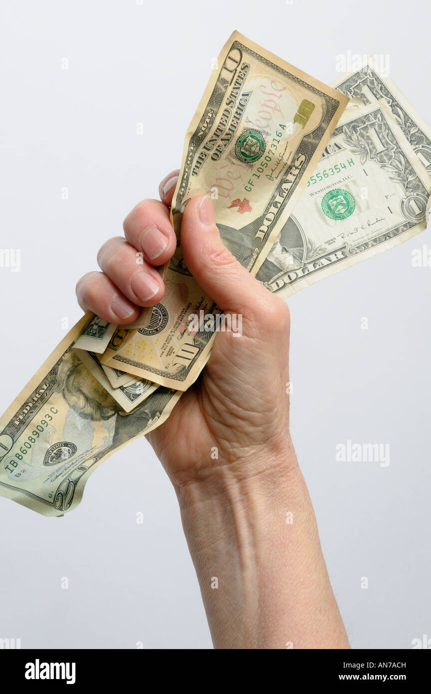 A hand prominently displays multiple dollars bills, showcasing various ...