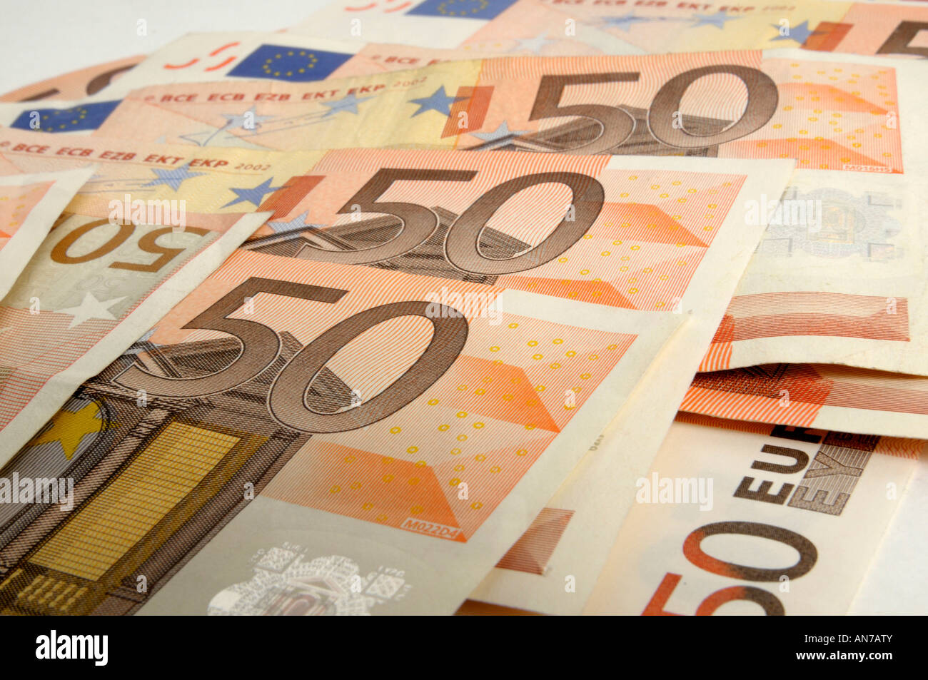 A collection of fifty euro banknotes is displayed on a flat surface ...