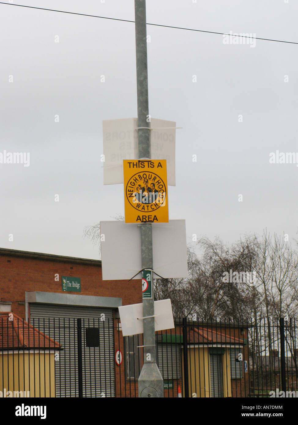 A yellow neighbourhood watch sign attached to a lamp post Stock Photo ...