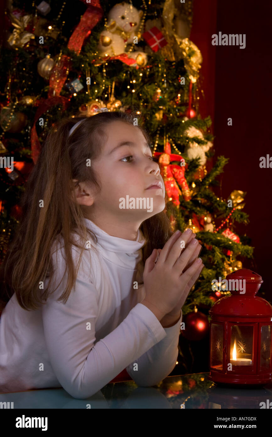 Prayers for Santa Claus. Little girl praying by the Christmas tree ...