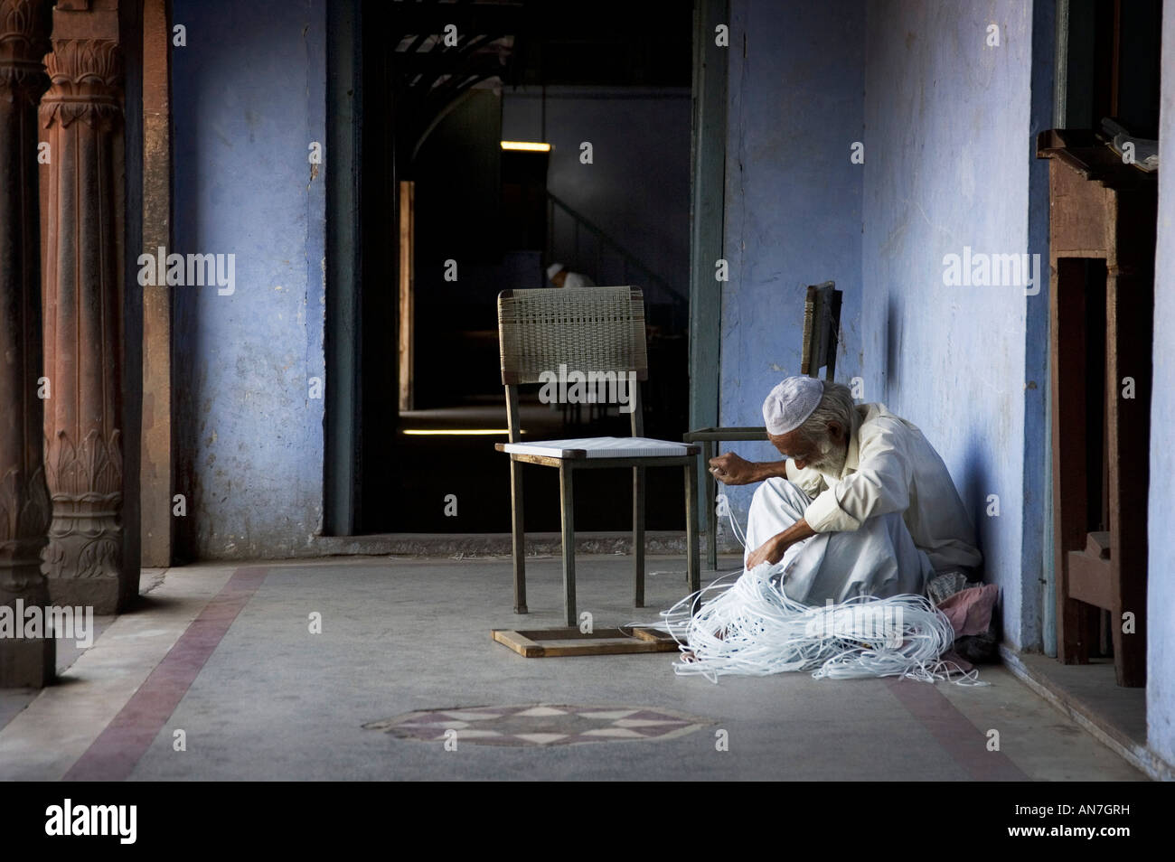 Old handy man repairing a rope chair in Delhi India Stock Photo - Alamy