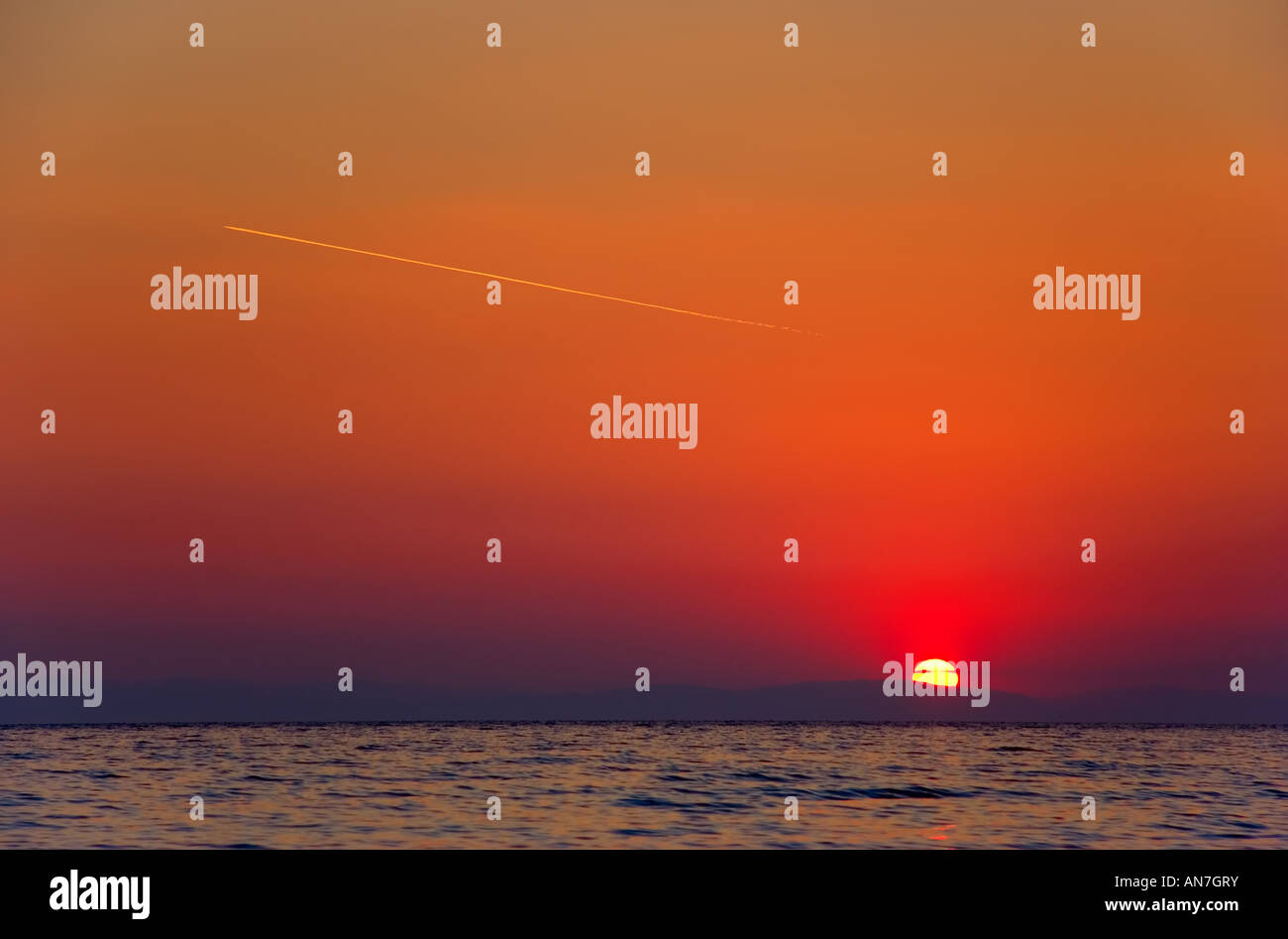 Sunrise with a plane flying on the sky Stock Photo - Alamy