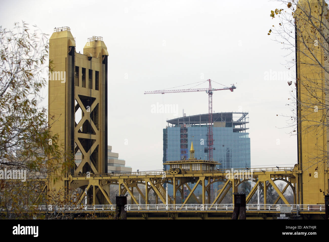 A crain at a construction site lifts building material to the top of a ...