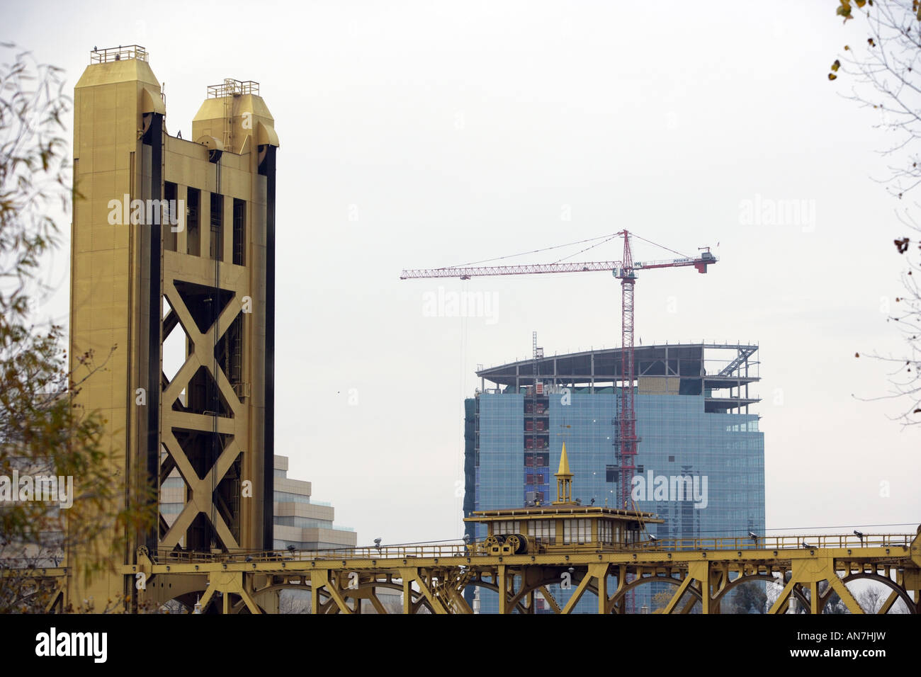 A crain at a construction site lifts building material to the top of a ...