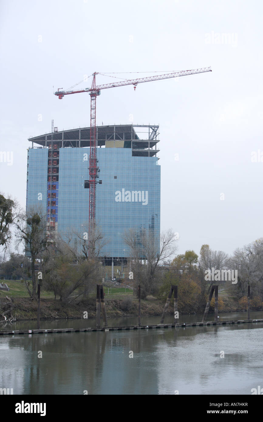 A crain at a construction site lifts building material to the top of a ...