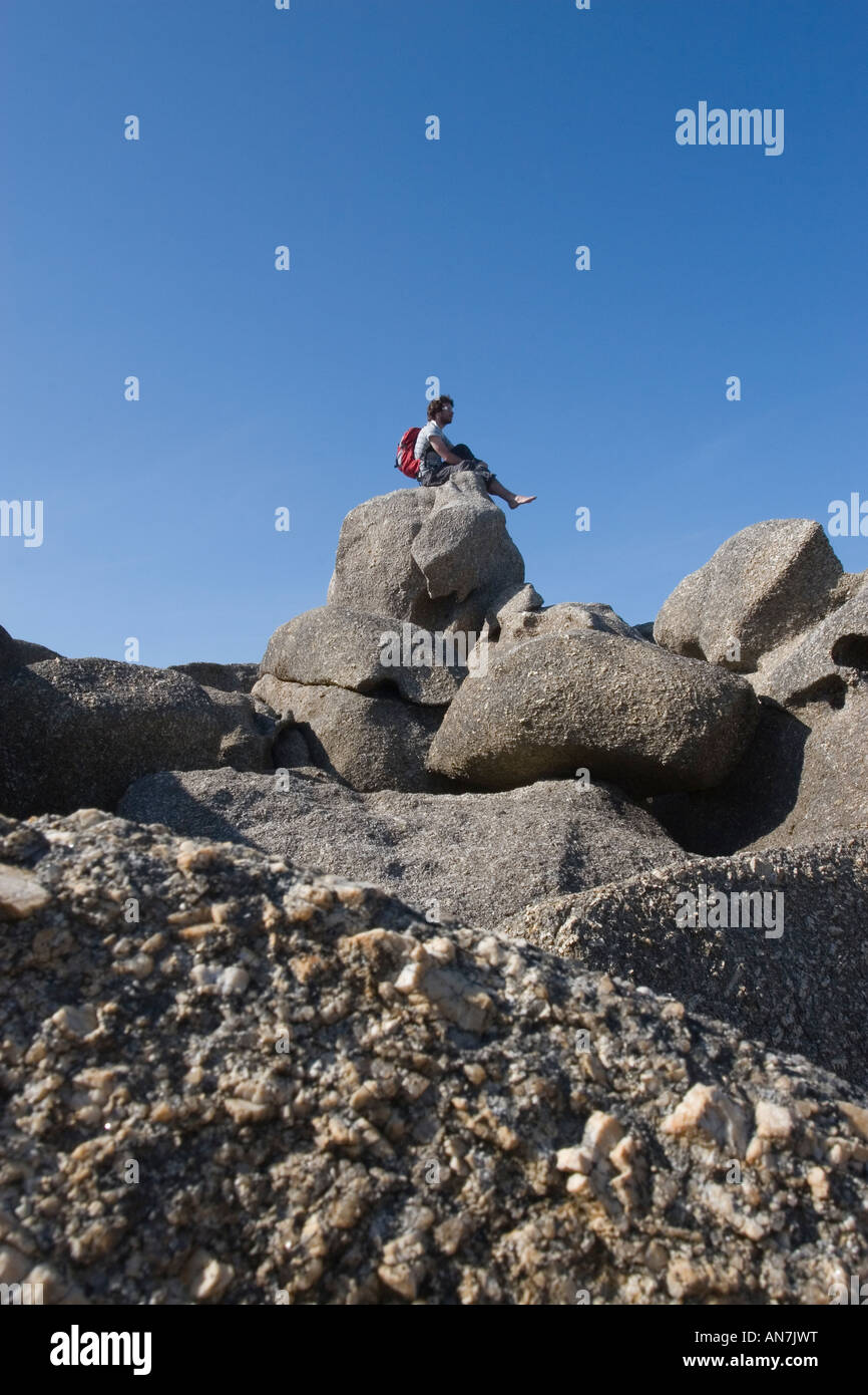 Male Sitting on Rock Stock Photo - Alamy