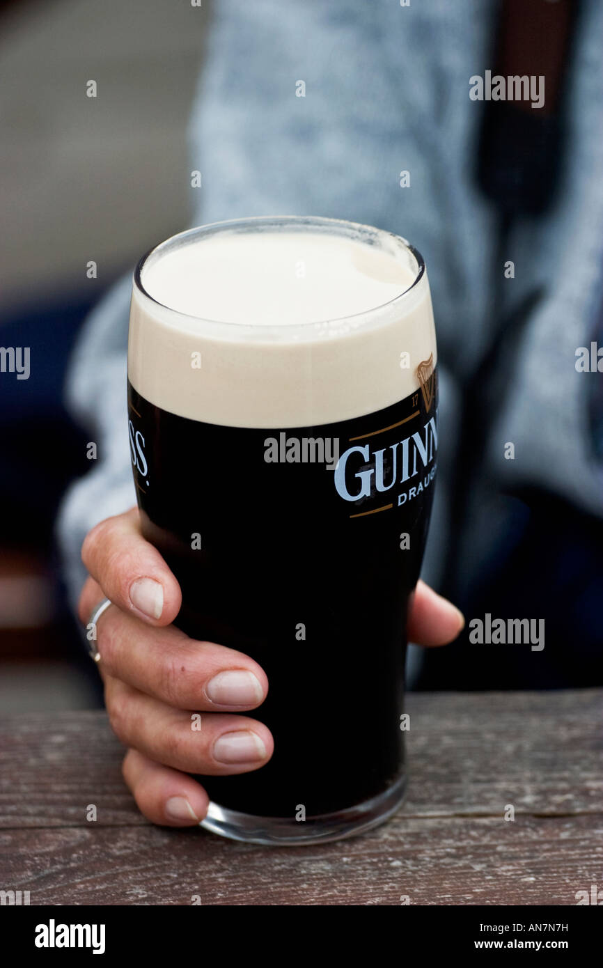 Woman hold a glass of Guinness on the table Stock Photo - Alamy