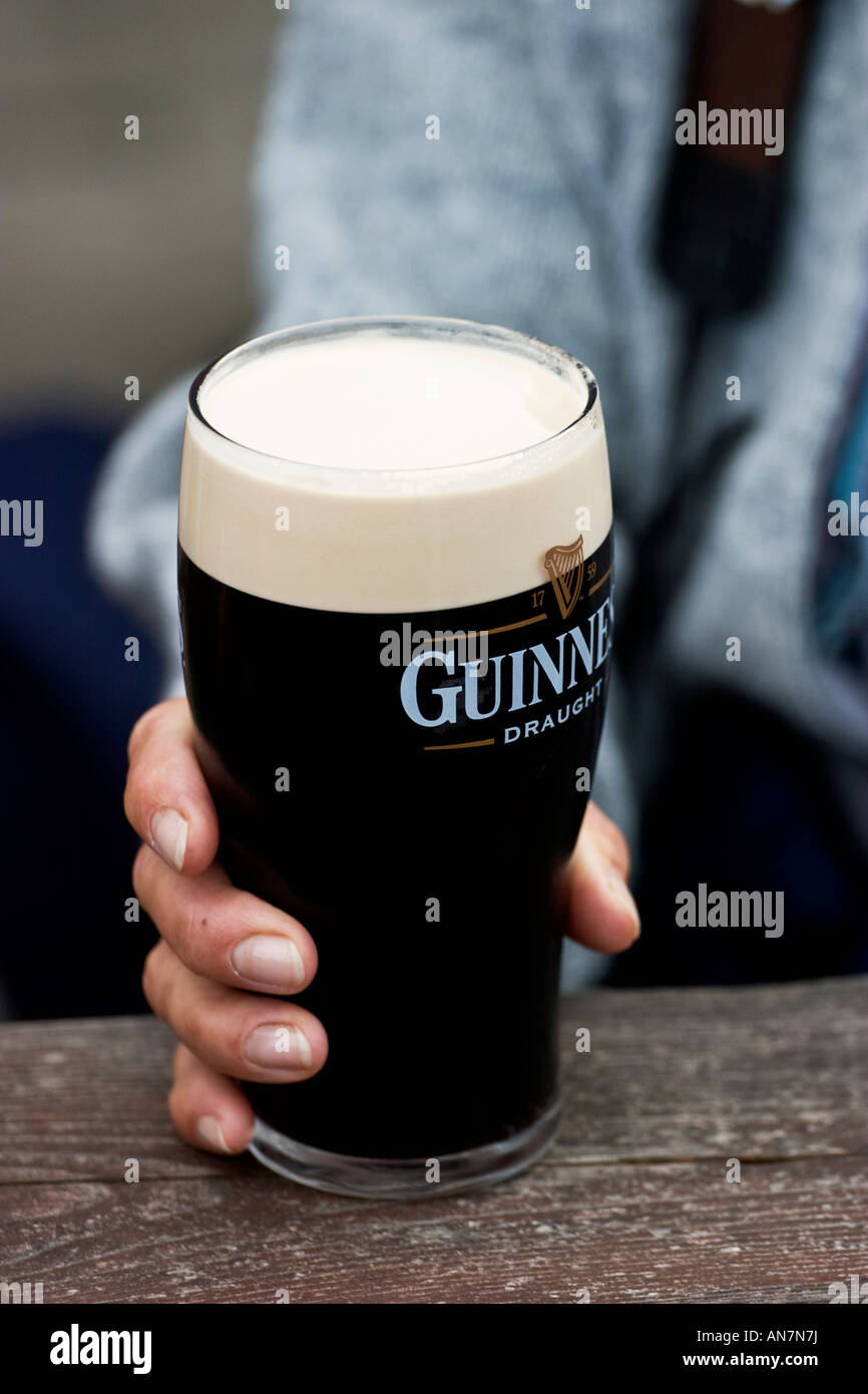 Woman hold a glass of Guinness on the table Stock Photo - Alamy