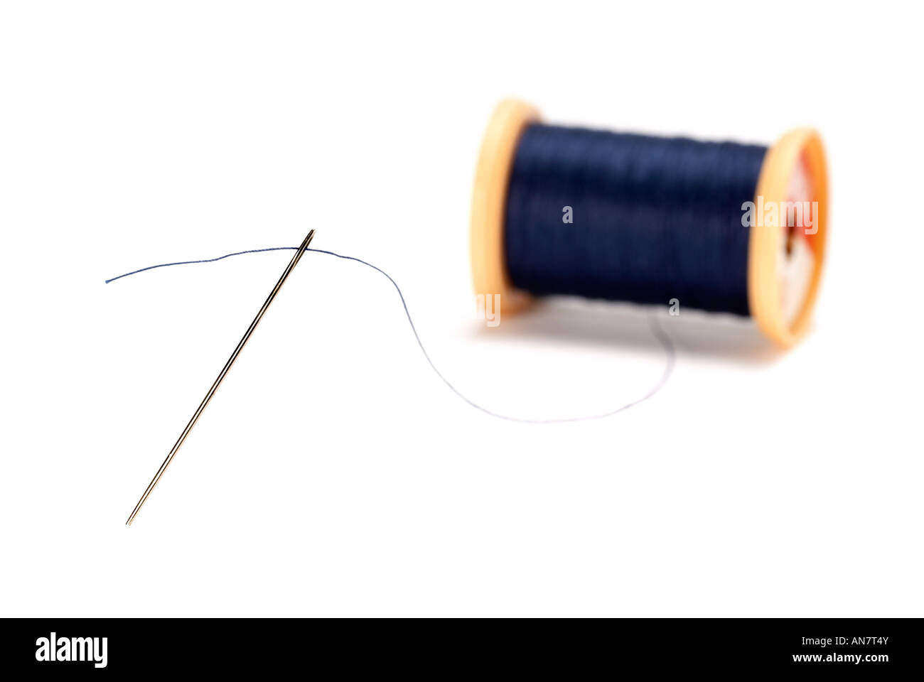 Blue cotton bobbin thread and needle Stock Photo - Alamy