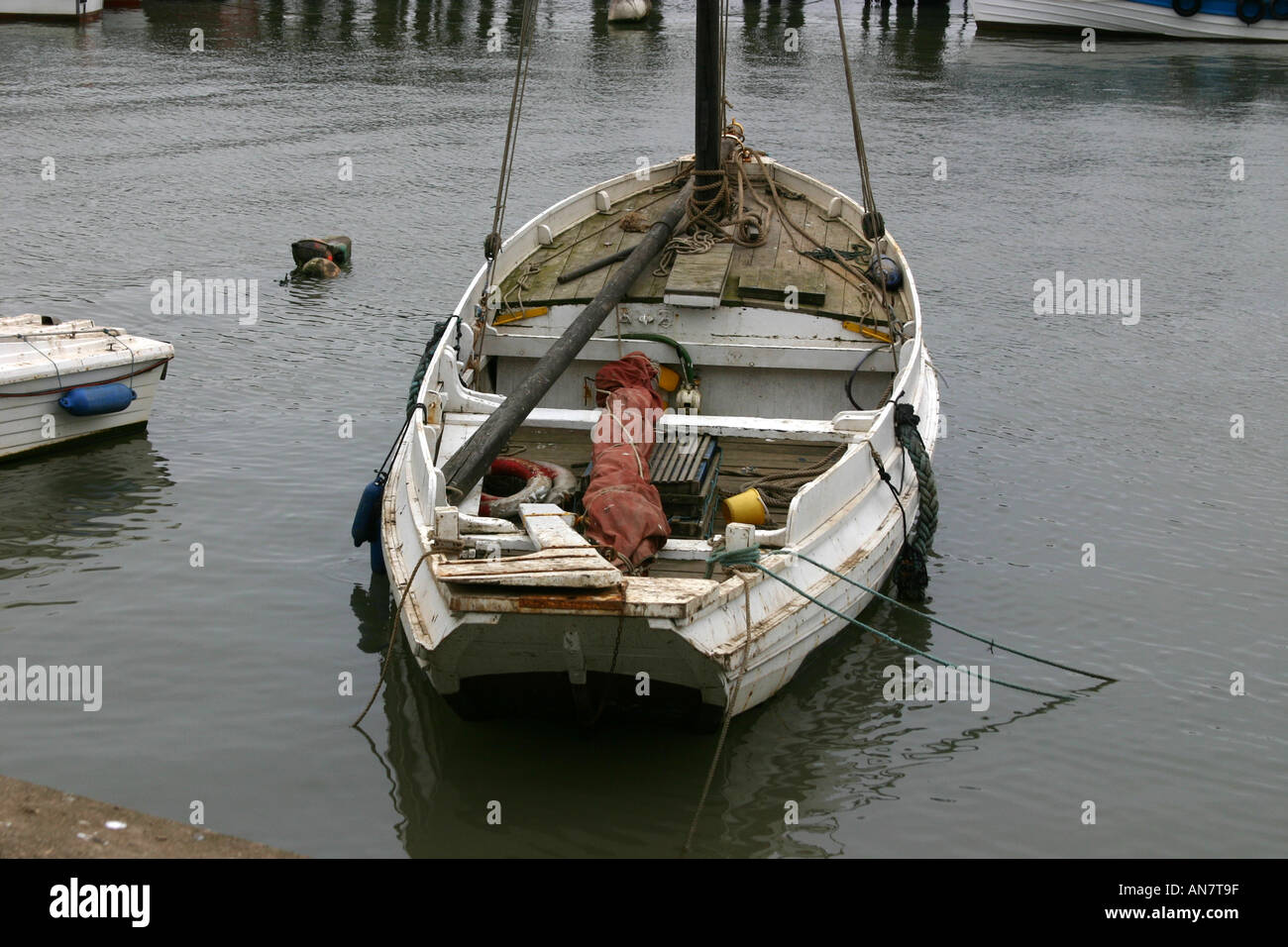Old fishing cobble with sail mast in harbour at Bridlington North ...