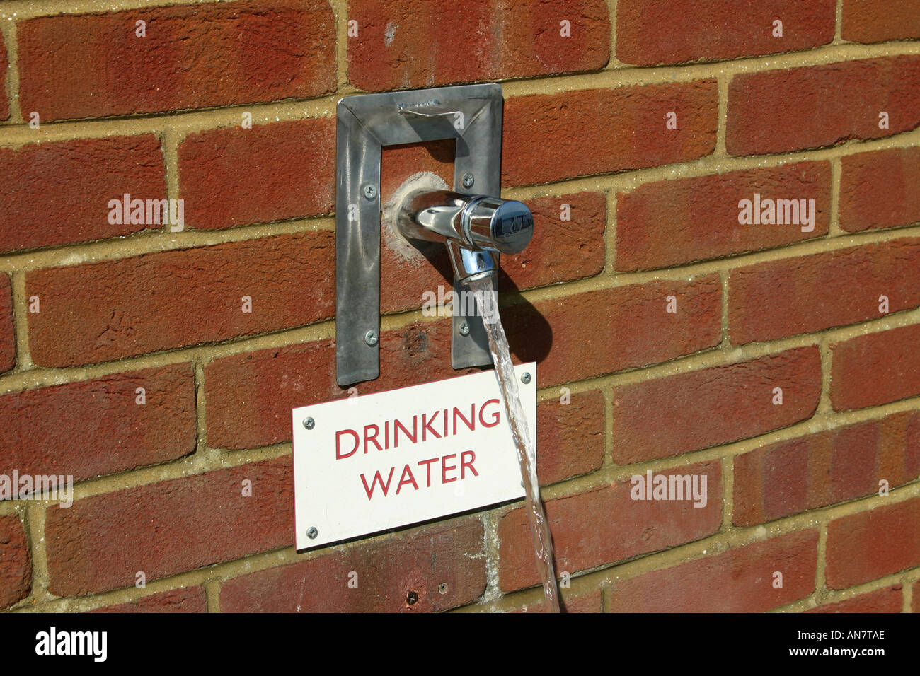 Public drinking water tap mounted on the side of a building at ...