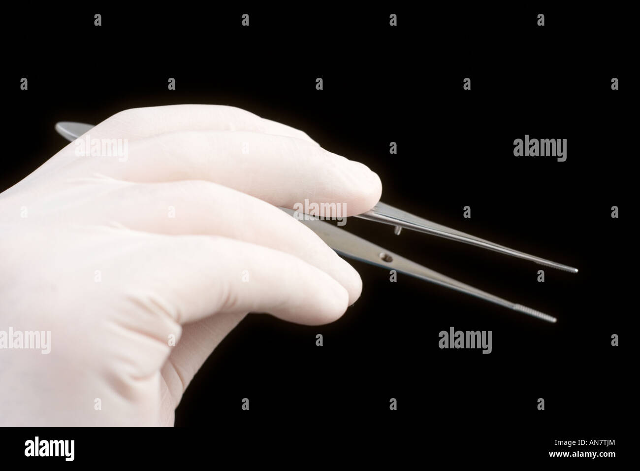 Hand holding tweezers Stock Photo - Alamy
