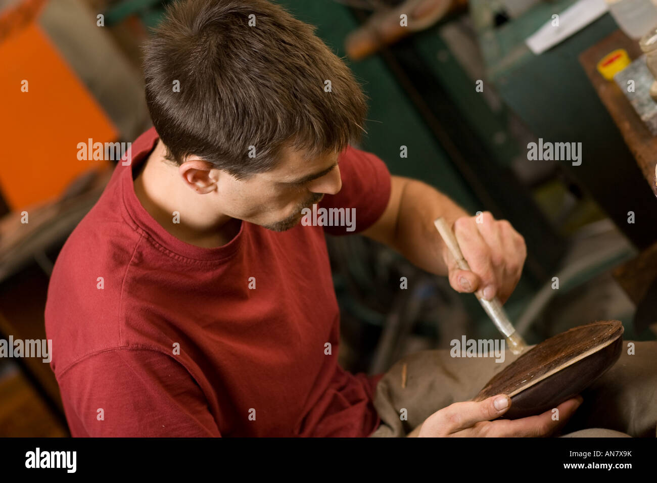 A shoe being made by a traditional shoe maker Glue is being applied to ...