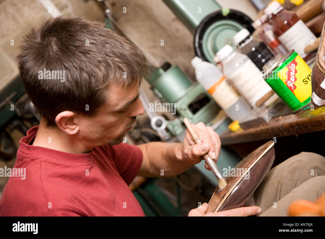 A shoe being made by a traditional shoe maker Glue is being applied to ...