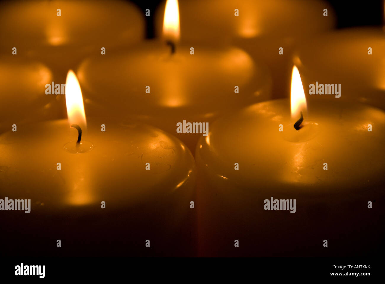 Side view of lit candles in total darkness Stock Photo - Alamy