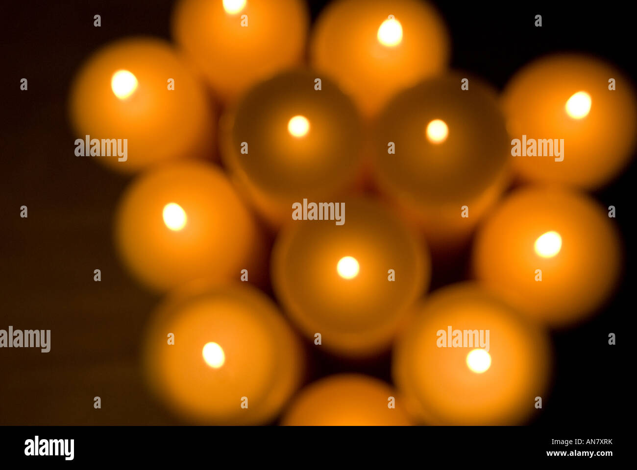 Candles viewed from above in darkness and deliberately out of focus ...