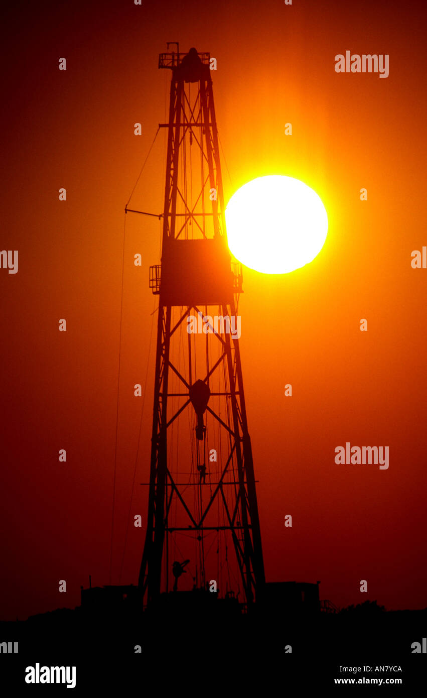 An oil rig is seen with a huge sun setting behind it Stock Photo - Alamy