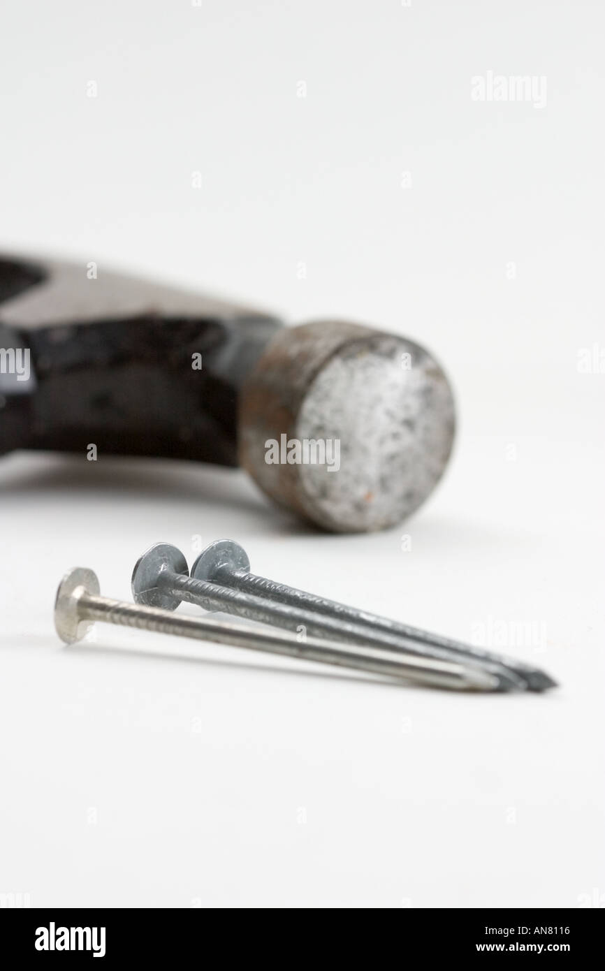 Three nails hammer in background Stock Photo - Alamy