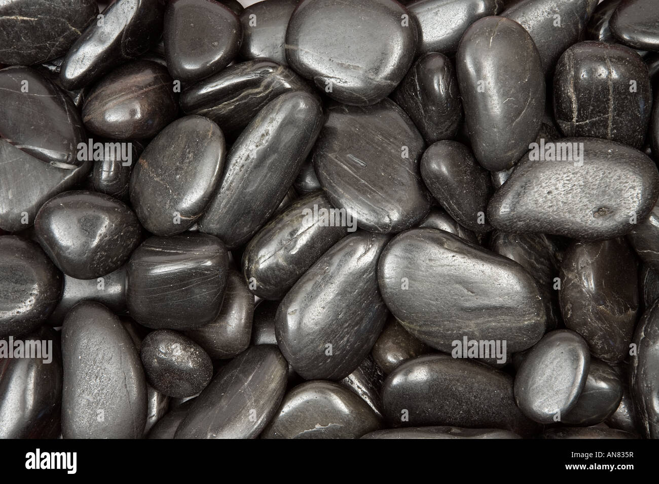 Tiny black stones forming a dark background Stock Photo - Alamy