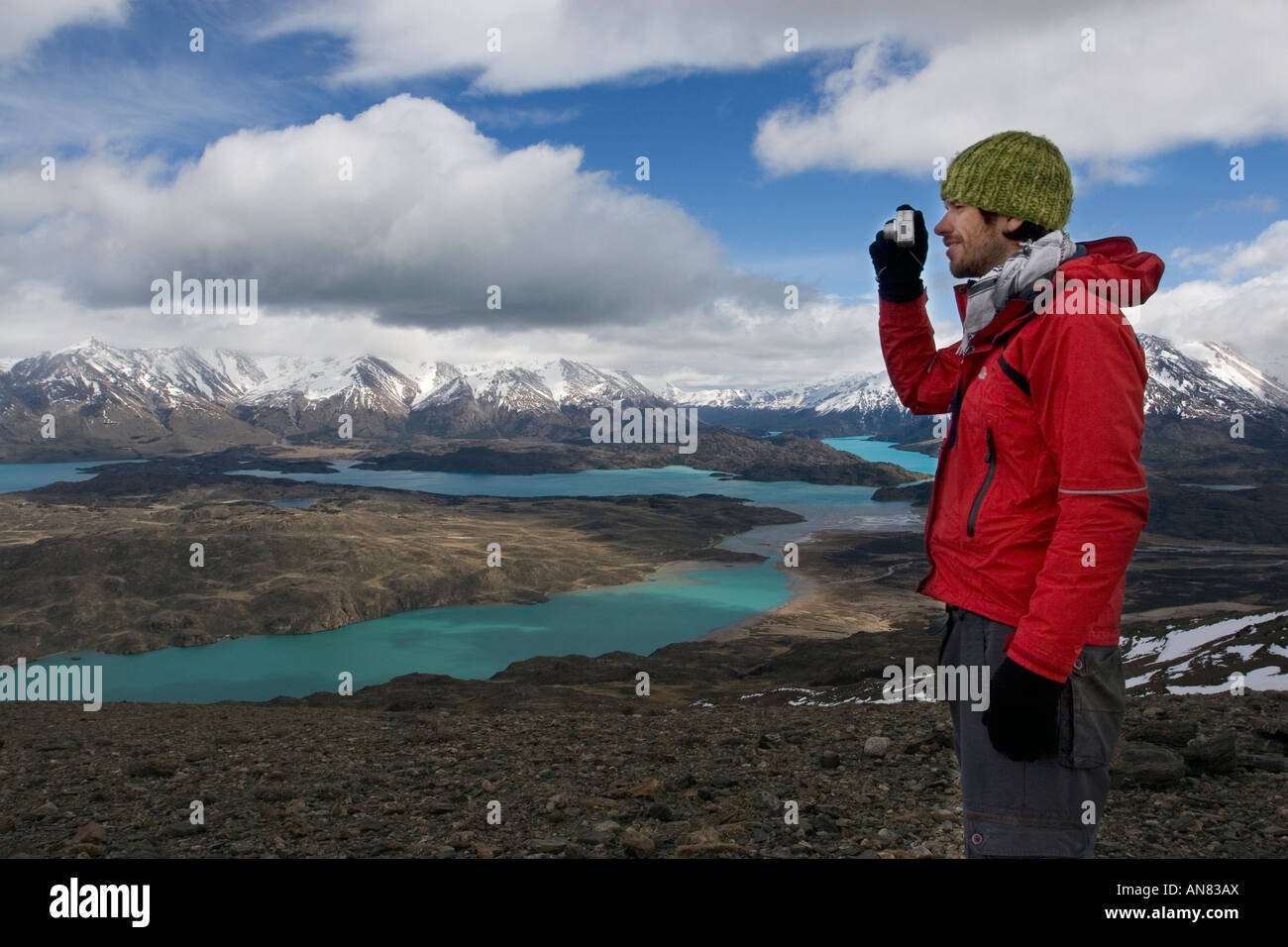 Man in red jacket takes picture of landscape Stock Photo - Alamy