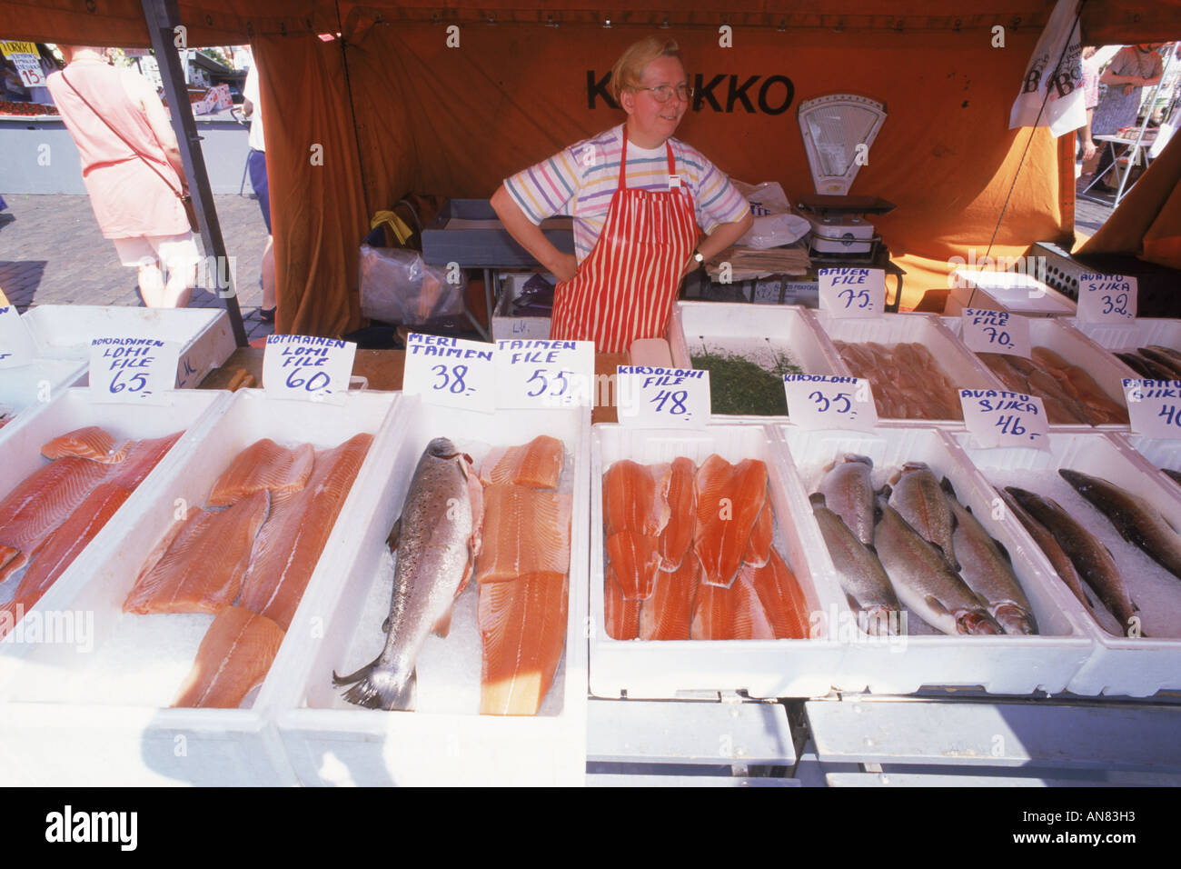 Female merchant selling fresh fish in outdoor market place at South ...