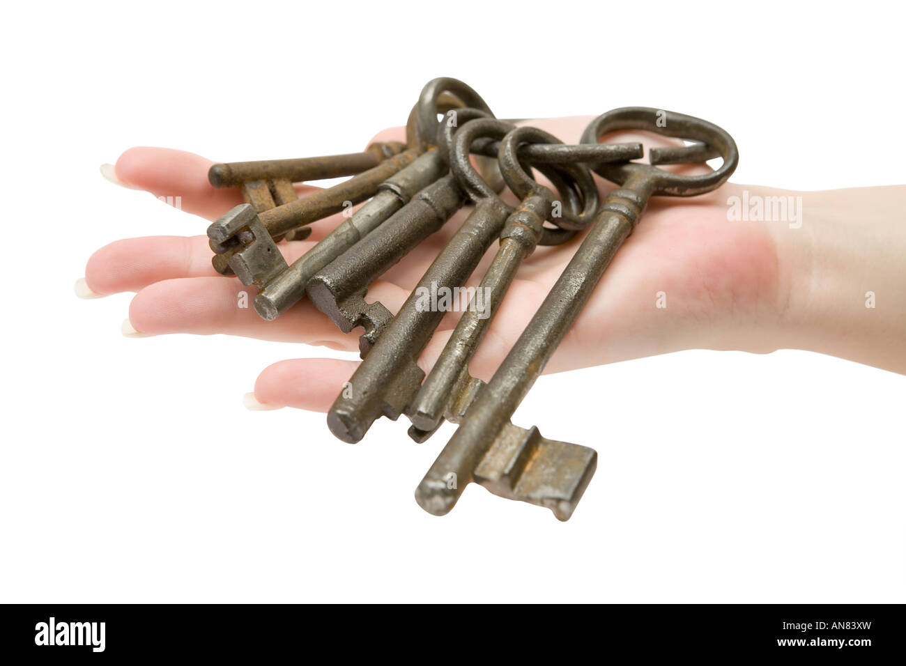 Female hand holding a rusty key ring. Isolated on a white background ...