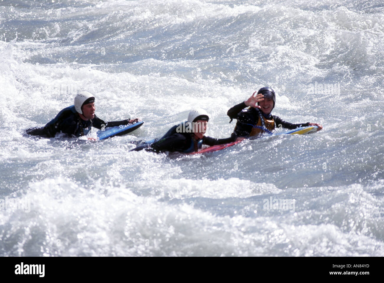 Three people river surfing on the Kawarau River Queenstown Stock Photo ...