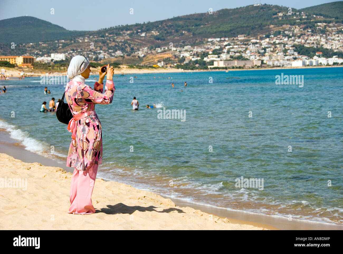 Muslim woman taking pictures on the beach, Tabarka, Tunisia Stock Photo ...