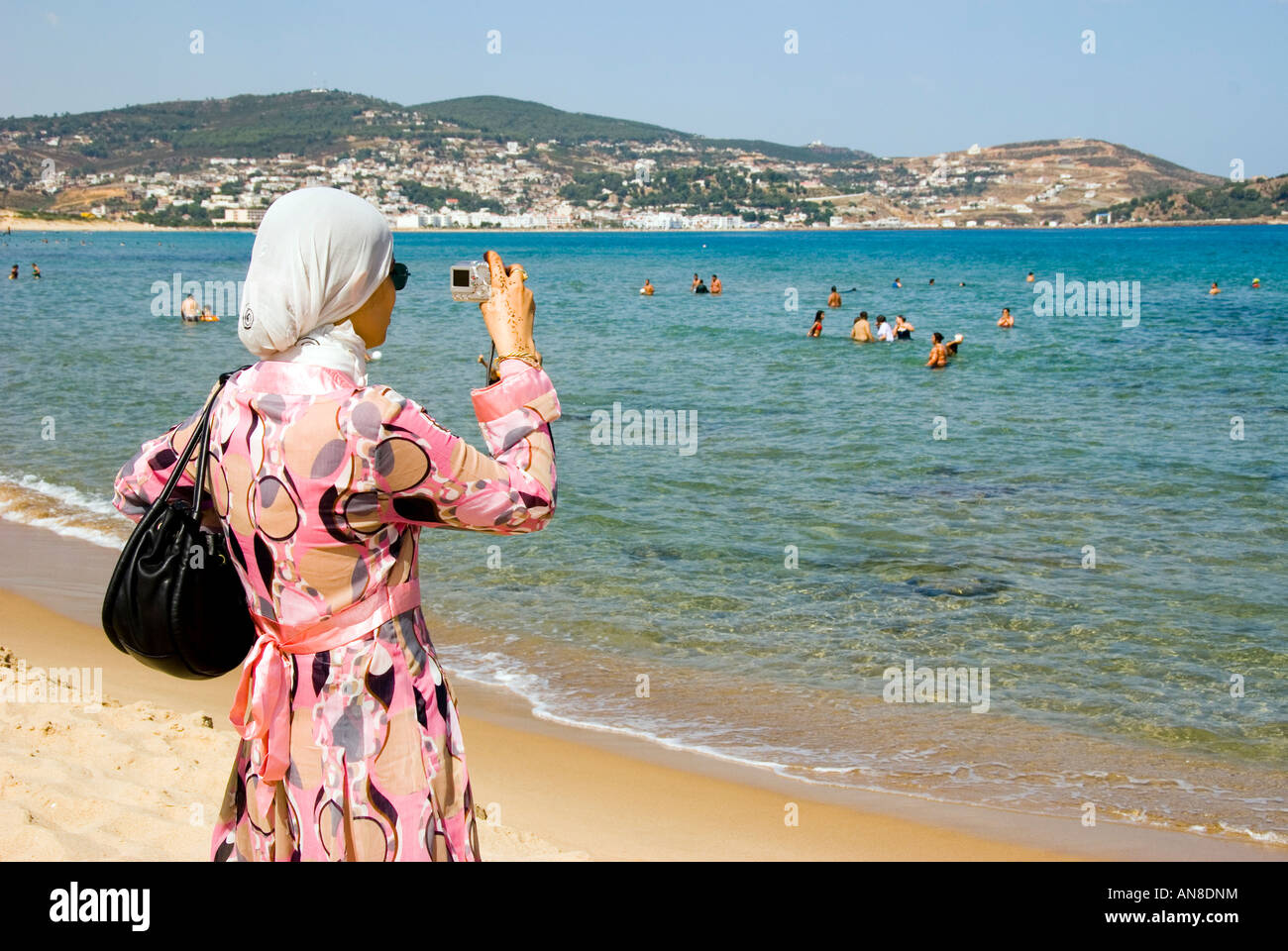 Muslim woman taking pictures on the beach, Tabarka, Tunisia Stock Photo ...